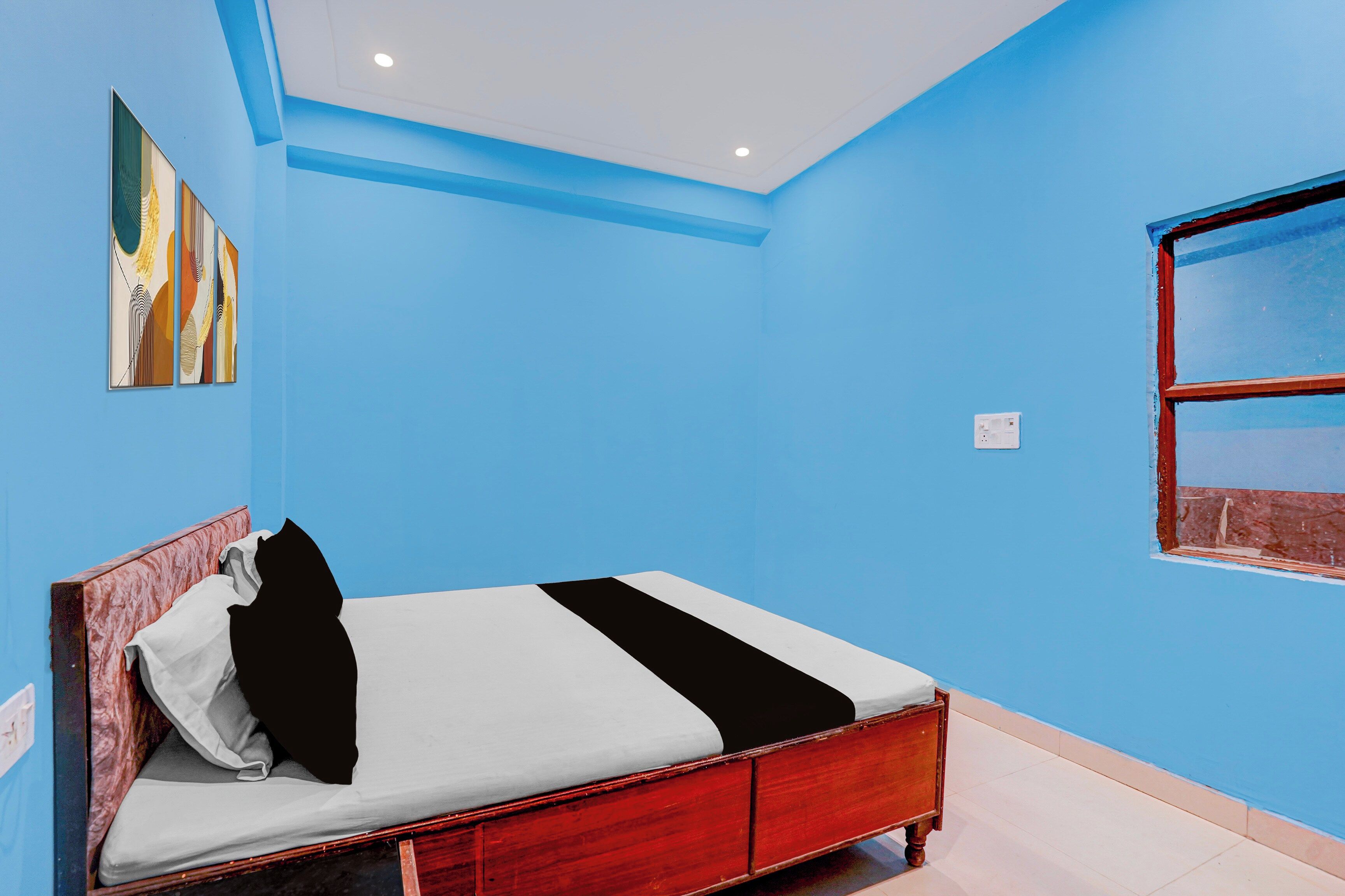 Quarto com cama, janela e parede decorada com um quadro.