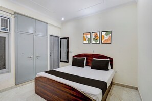 Quarto com cama, guarda-roupa e uma obra de arte na parede.