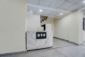Uma receção com design em mármore e o letreiro 'OYO'.