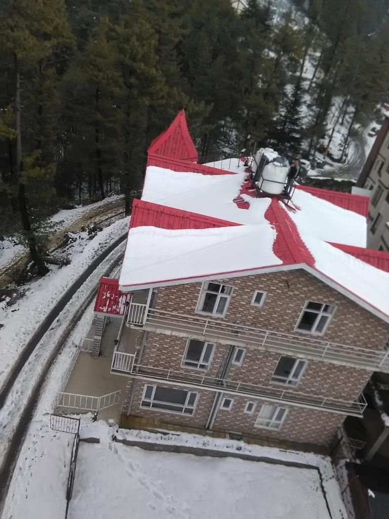 Um edifício de dois andares com telhado vermelho e uma varanda.