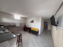 Espaço compacto para viver, com cozinha compacta, área de refeições e sofá.