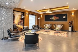 Um interior moderno com sofás de couro, uma mesa de centro redonda e um detalhe decorativo na parede.