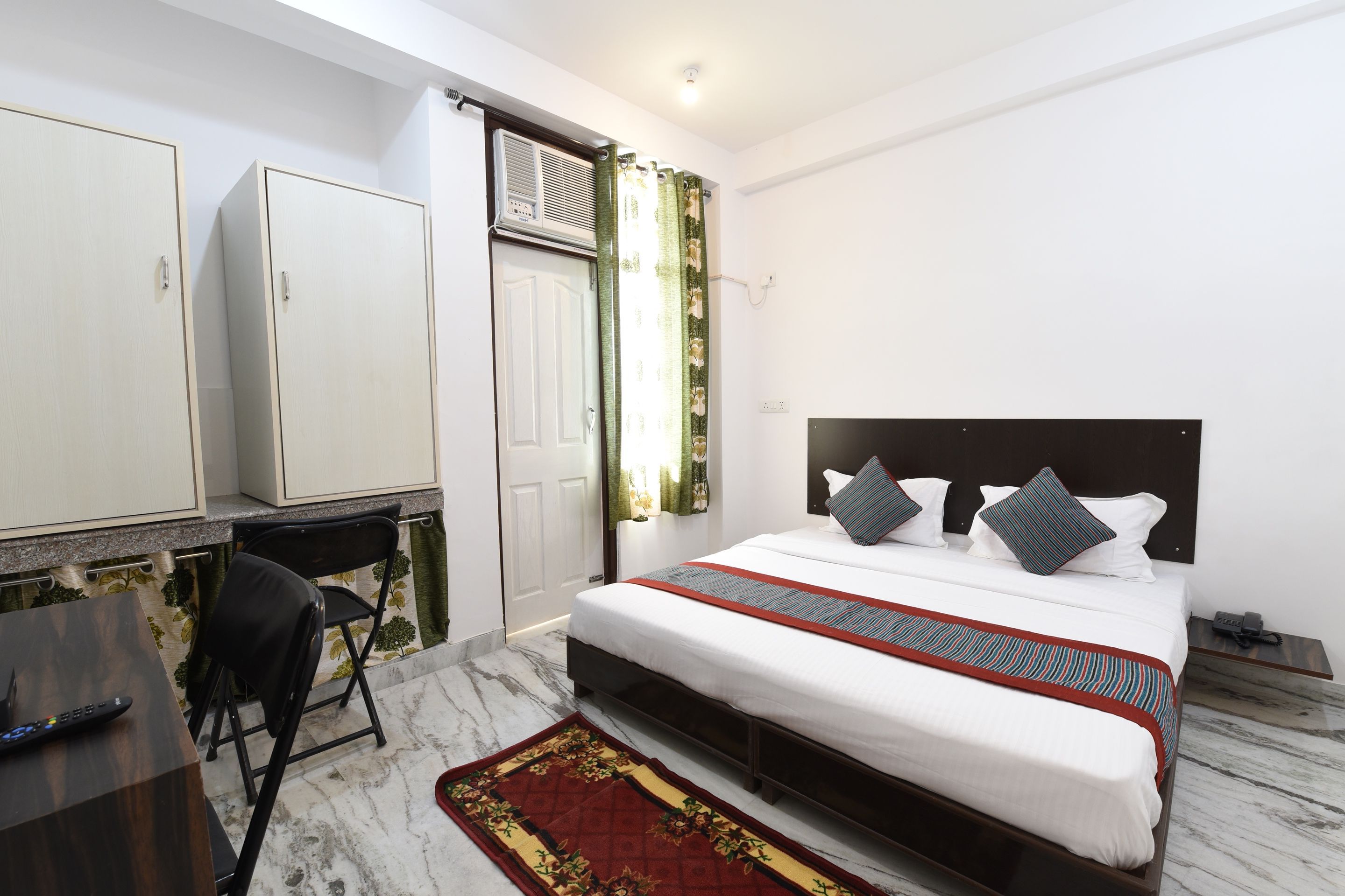 Quarto com cama, escrivaninha, cadeira e guarda-roupa.