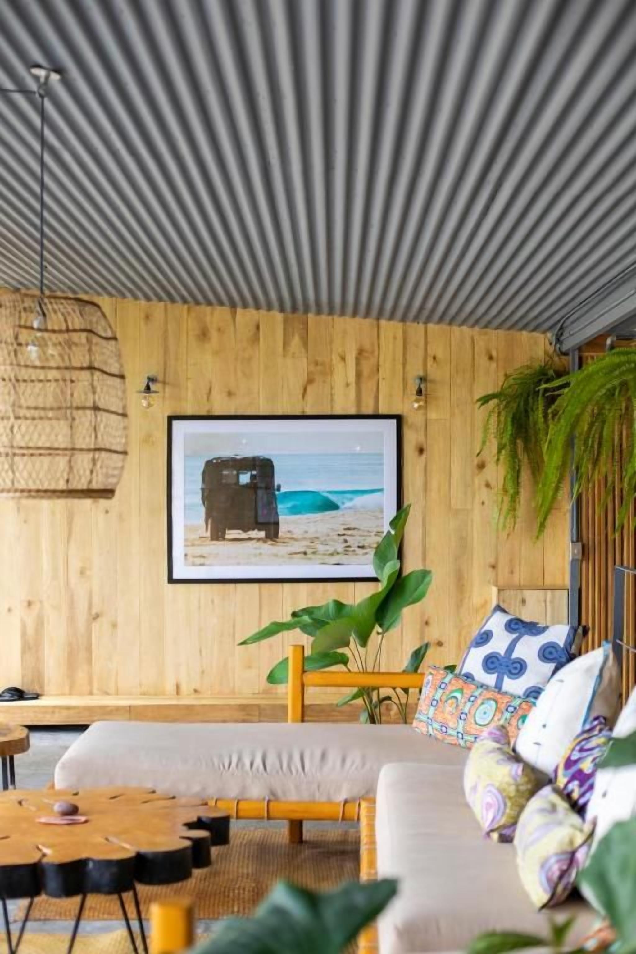 Quarto com parede de madeira, um quadro emoldurado, um sofá e uma mesa de centro.