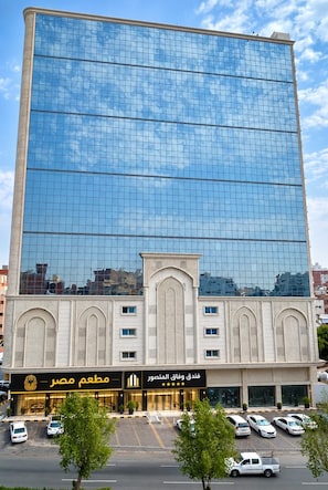 Edifício moderno com fachada de vidro refletindo o céu.