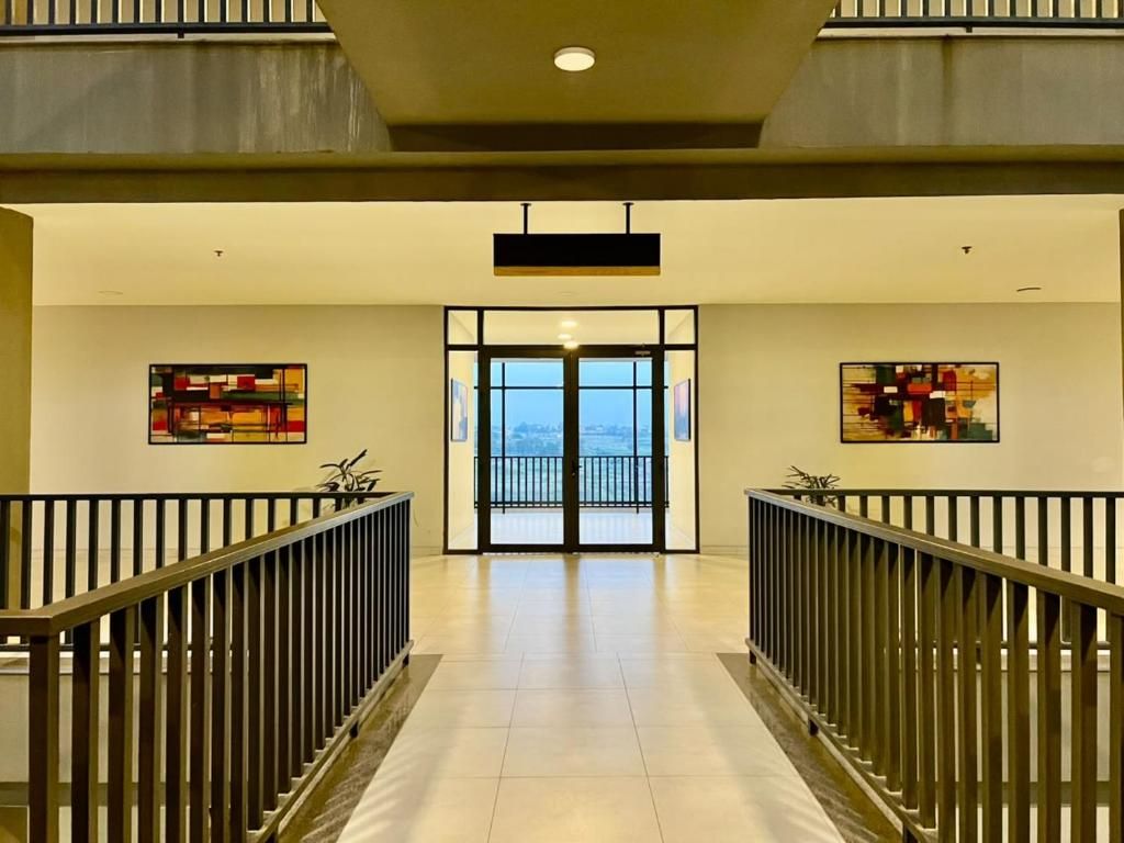 Um hall de hotel com entrada dupla central, duas grades laterais e obras de arte nas paredes.