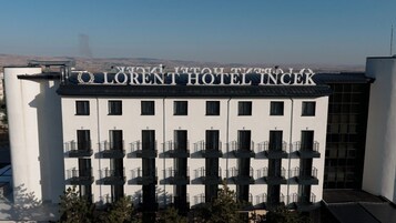 Um edifício de hotel com uma placa indicando 'LORENTH HOTEL INCEK' e várias varandas.
