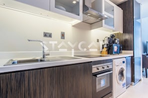 Cozinha moderna equipada com lava-louças embutida, forno e micro-ondas.