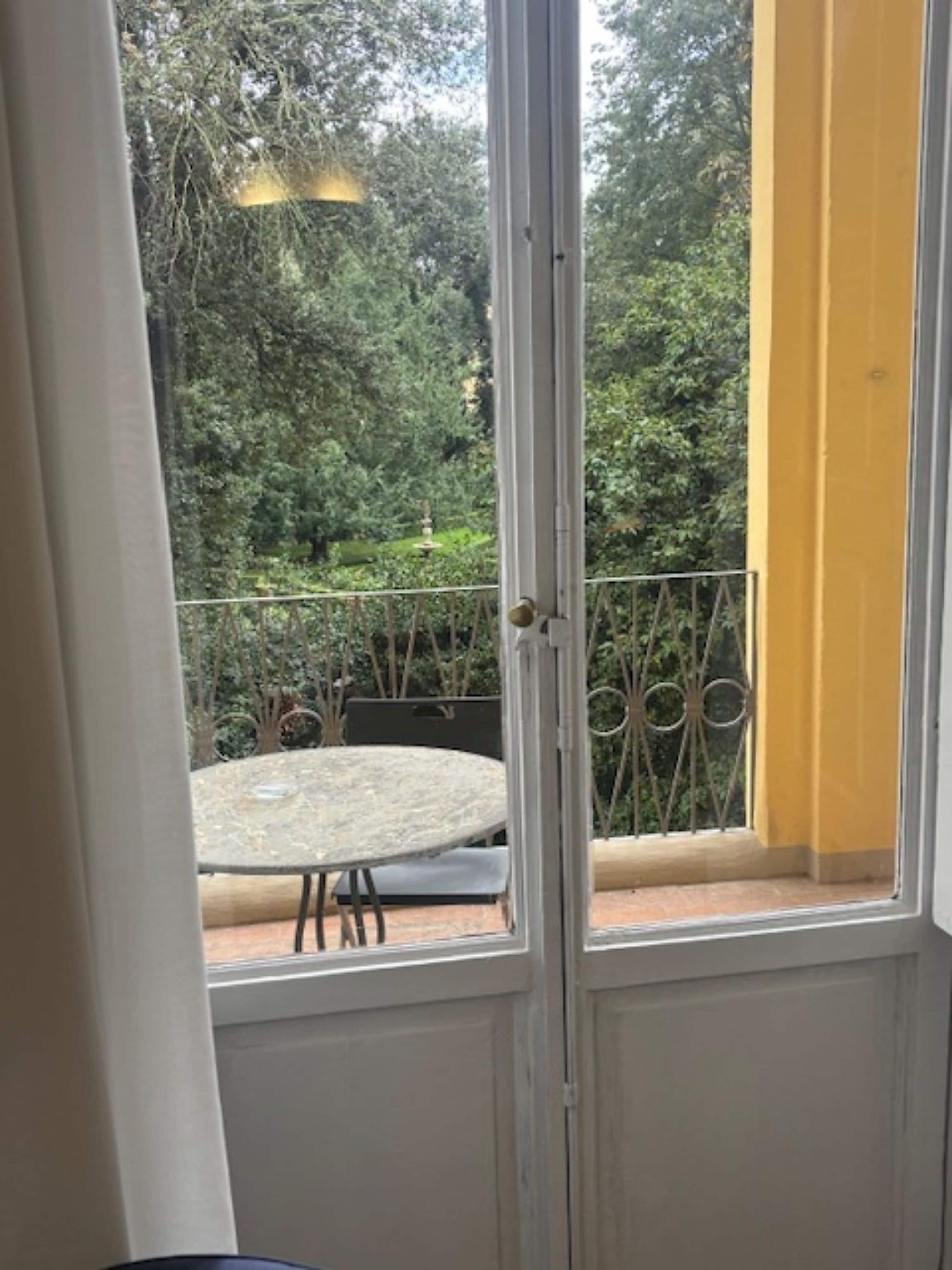 Quarto com vista para um jardim através de uma janela.