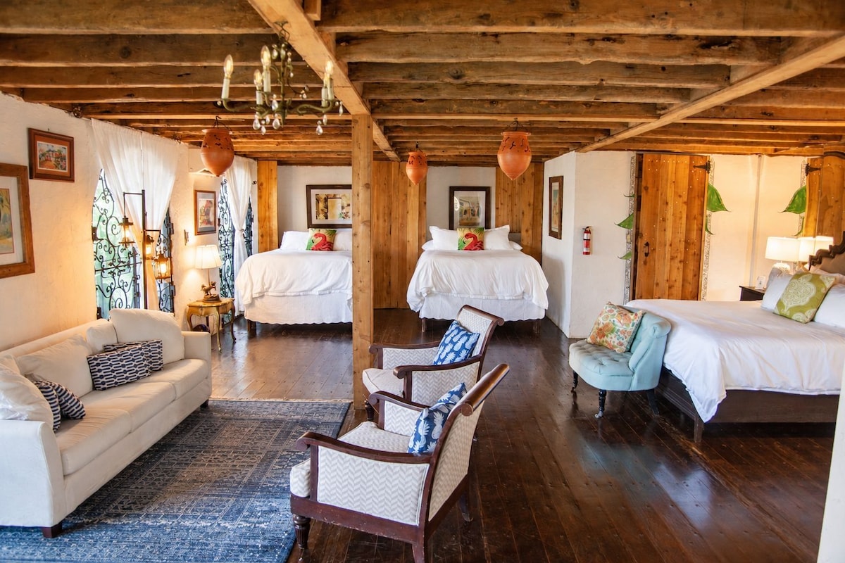 Um quarto de hotel acolhedor com duas camas, um sofá e uma poltrona.