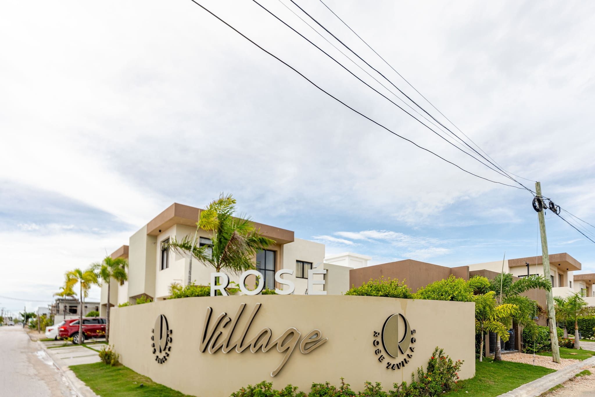 Área residencial com uma placa indicando 'Rose Village', sinalizando uma comunidade ou bairro.