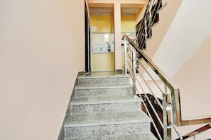 Uma escadaria com corrimão de metal que leva a um patamar.