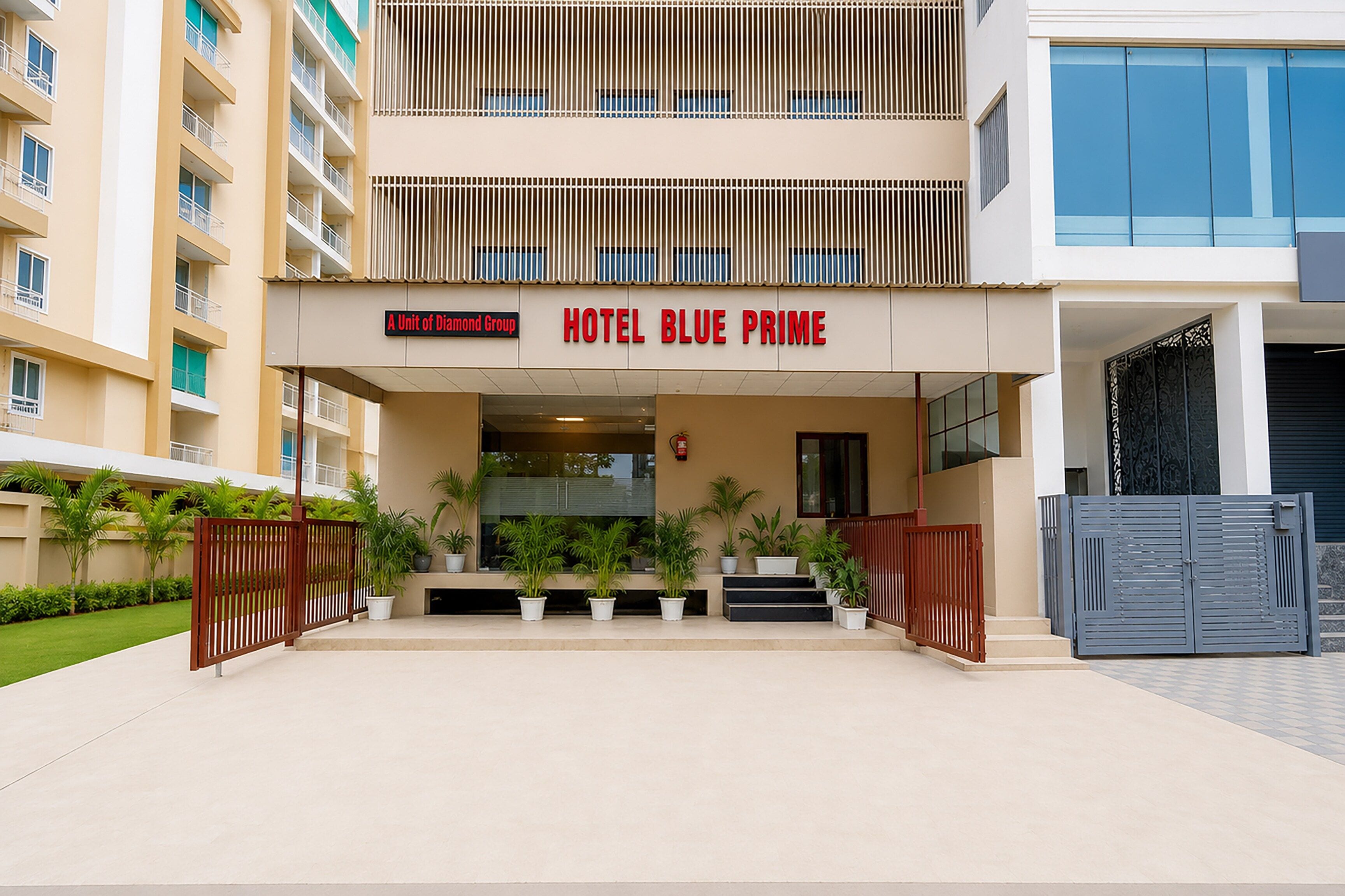 Entrada de hotel com placa indicando 'HOTEL BLUE PRIME' e uma unidade do Grupo Diamond.