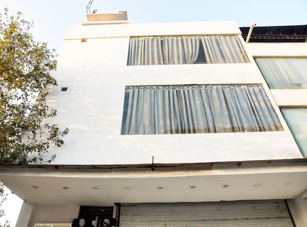 Um edifício moderno com duas janelas visíveis, um telhado plano e um toldo fechado.