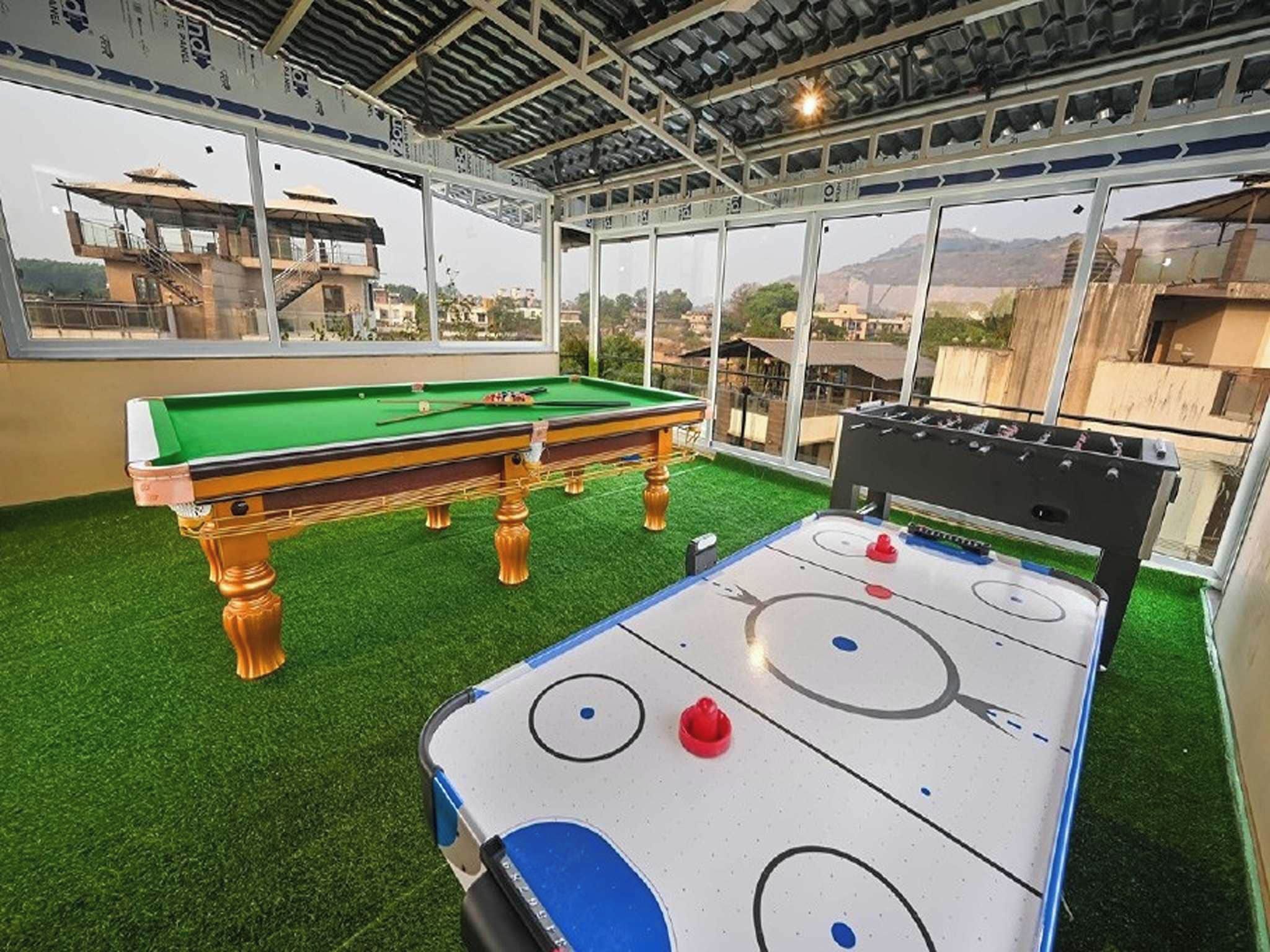 Espaço de lazer coberto com mesa de bilhar e mesa de futebol de mesa.