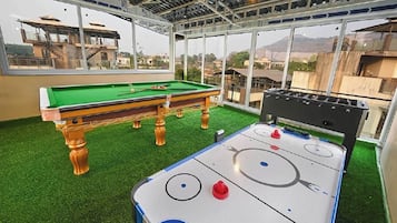 Espaço de lazer coberto com mesa de bilhar e mesa de futebol de mesa.