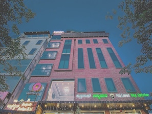 Edifício de vários andares com fachada de tijolos, janelas amplas e placa com a inscrição 'Palavas Veg Cuisine'.