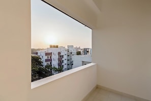 Varanda com vista para a paisagem urbana ao pôr do sol.