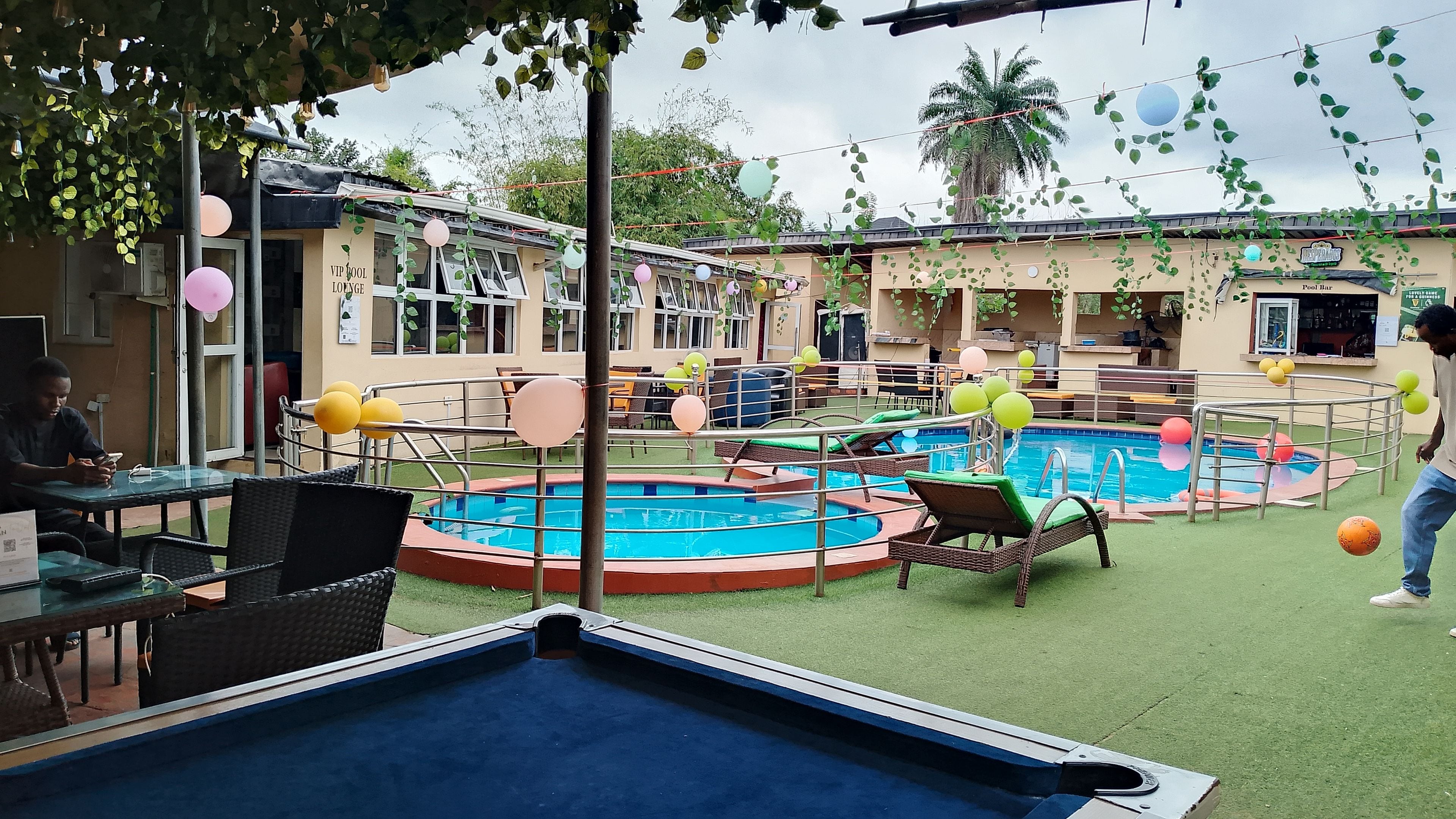 Área de piscina com espreguiçadeiras, piscina e um lounge VIP.