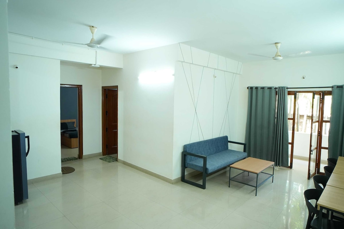 Uma sala de estar ampla com sofá, mesa de jantar e ventilador de teto.