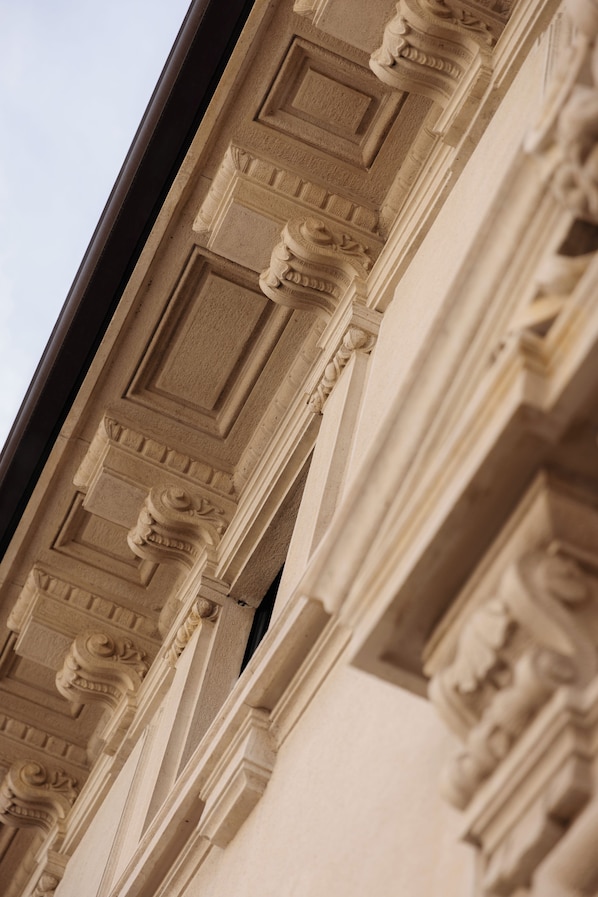 Detalhe da arquitetura de um edifício, com molduras ornamentadas e uma série de painéis retangulares.
