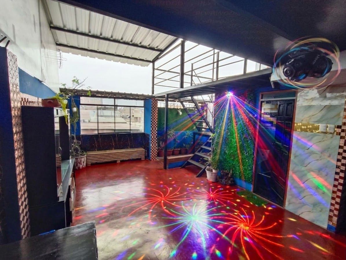 Espaço interior com escada, teto com luminária e parede com textura.