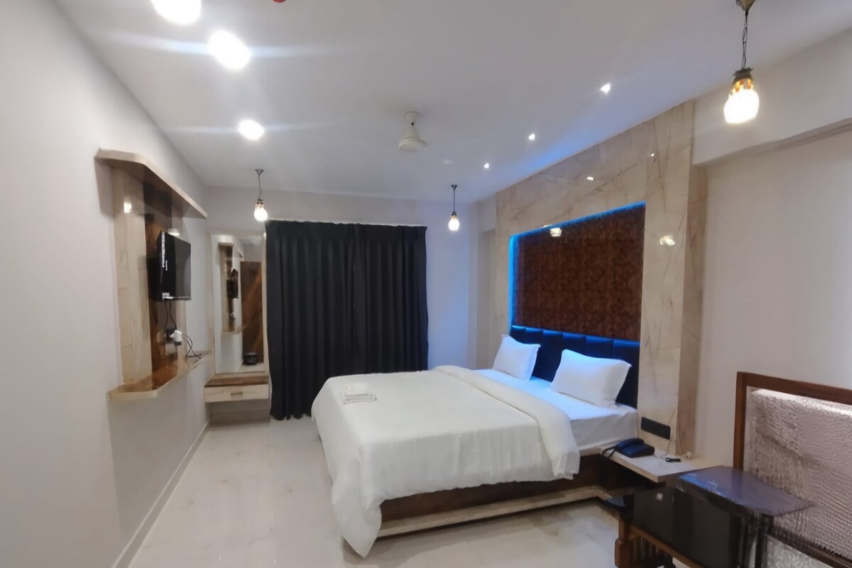 Quarto moderno com cama, mesa de cabeceira e escrivaninha com cadeira.
