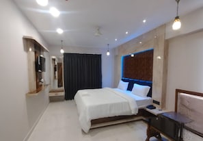 Quarto moderno com cama, mesa de cabeceira e escrivaninha com cadeira.