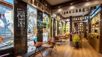 Restaurante com mobiliário de madeira, janelas amplas e lanternas penduradas.