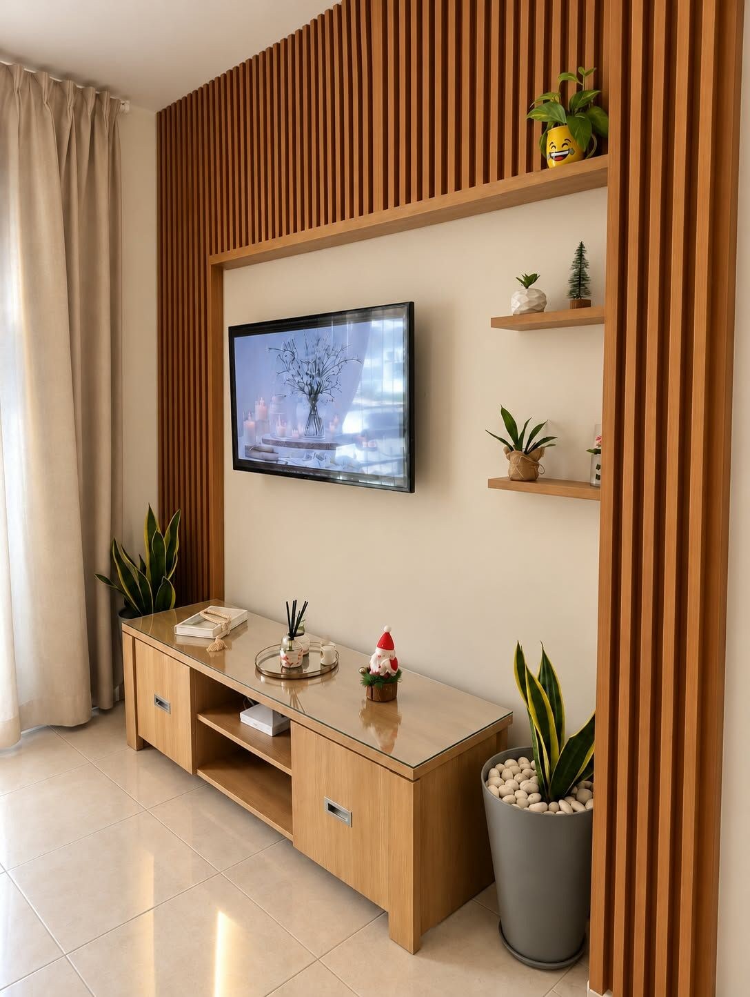 Sala de estar moderna com televisão montada em parede de madeira, mesa de consola de madeira e plantas em vasos.
