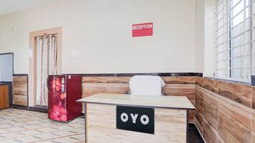 Um balcão de atendimento com uma placa indicando 'RECEPTION' e uma placa com o logotipo 'OYO'.