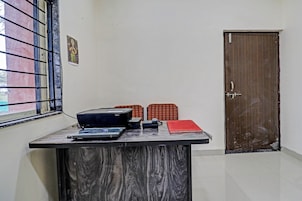 Quarto com escrivaninha, porta e janela com grades.