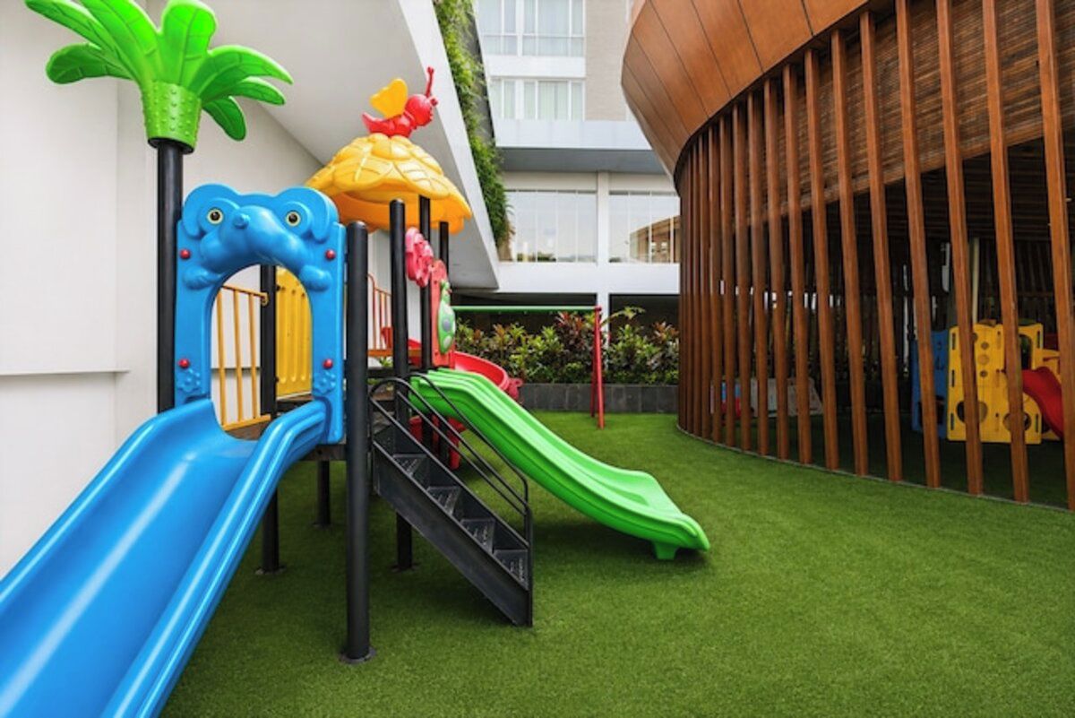 Espaço de recreação infantil com escorregadores e estruturas de escalada.