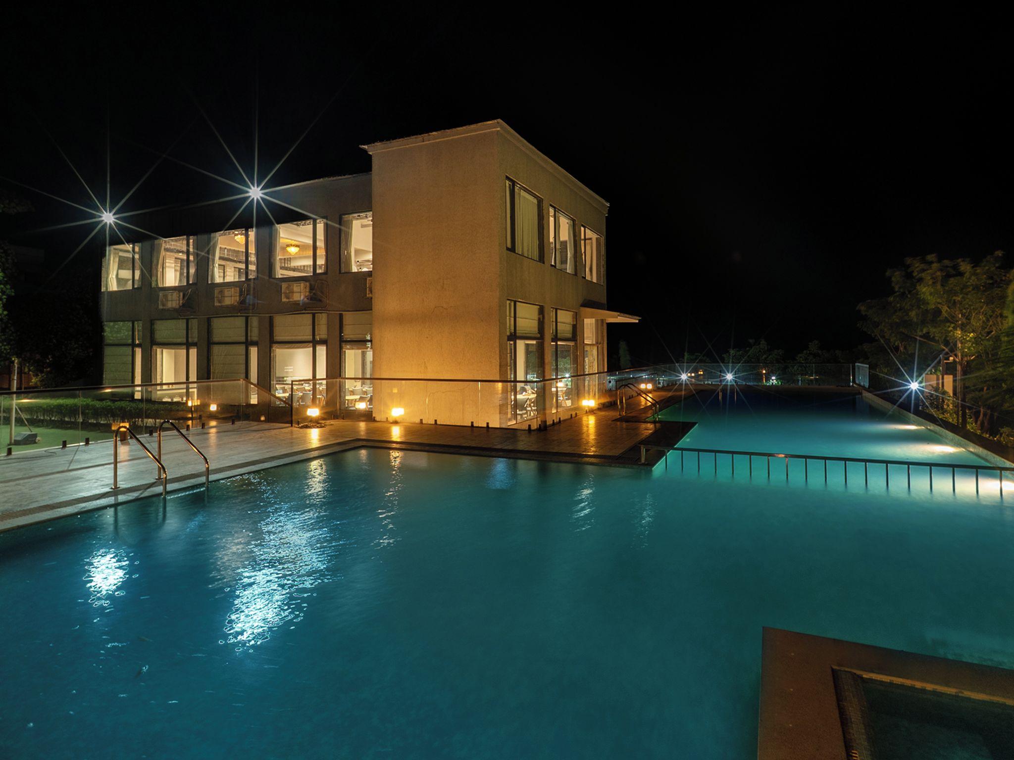 Um edifício moderno com piscina à noite.