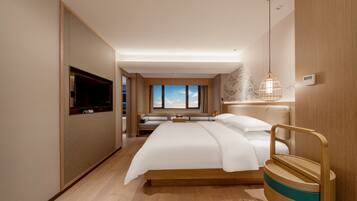 Quarto de hotel moderno com cama grande, televisão, aquecedor fixado na parede e vista do céu pela janela.