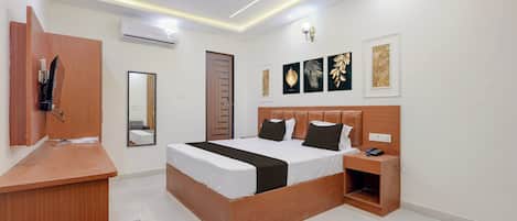 Quarto moderno com cama de madeira, mesas de cabeceira, escrivaninha e espelho.