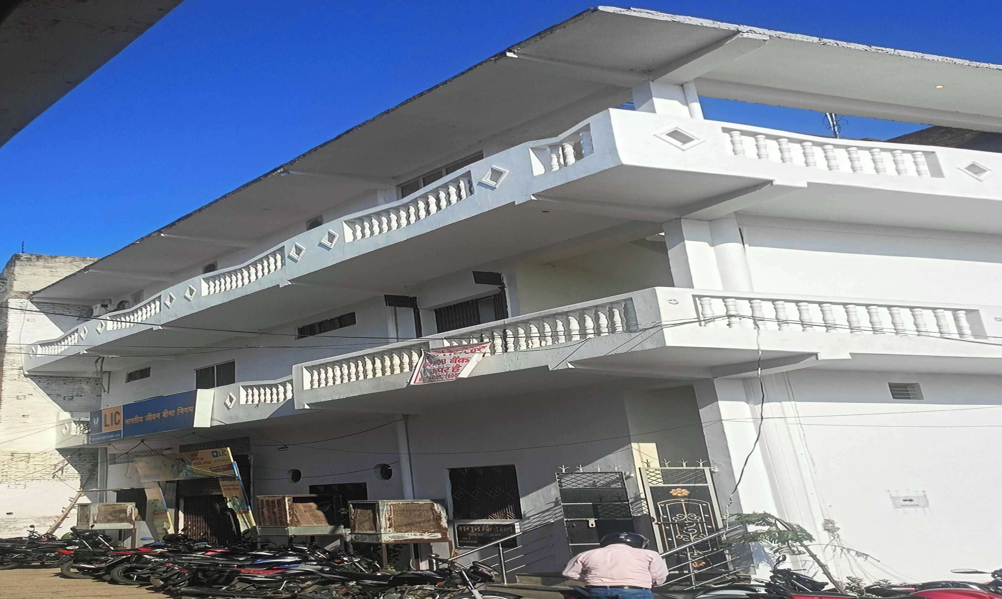 Um edifício com várias andares, varandas e entrada no nível da rua.