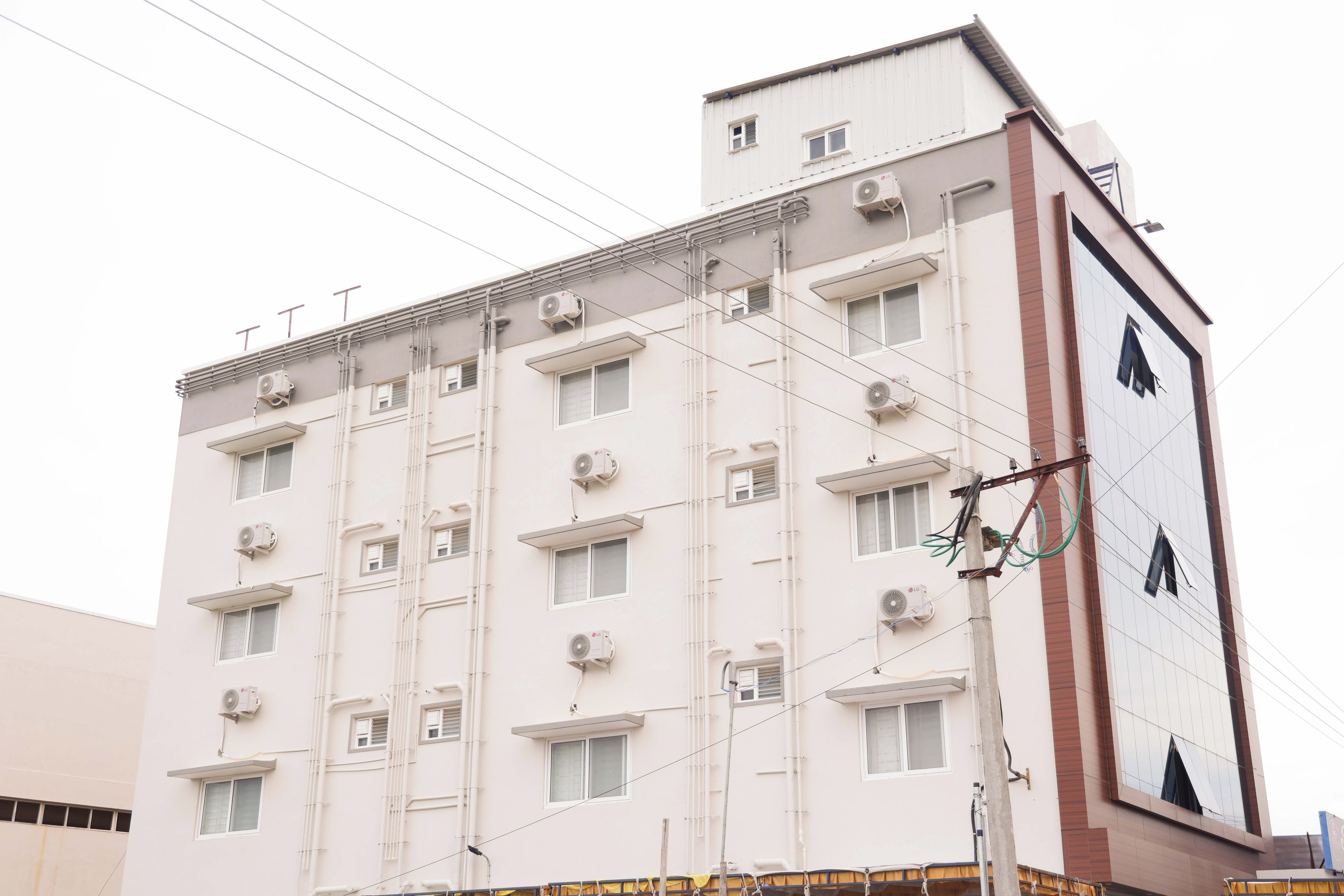 Um edifício alto com muitas janelas e aparelhos de ar condicionado.