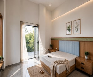 Quarto com cama, mesas de cabeceira, cortinas na janela e vista para o verde lá fora.