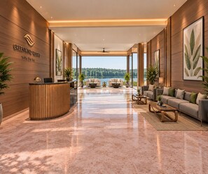 Um hall amplo com balcão de recepção, área de estar e uma grande janela com vista para um lago e uma floresta.