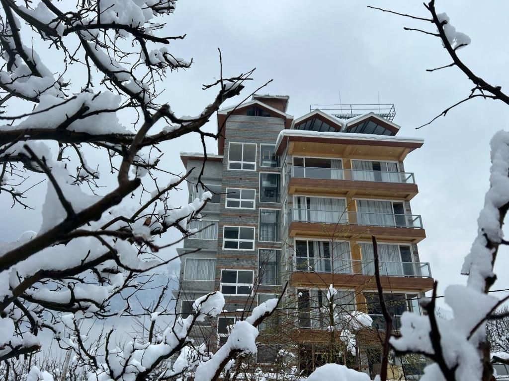 Um edifício com várias andares e varandas, possivelmente um hotel ou complexo de apartamentos.