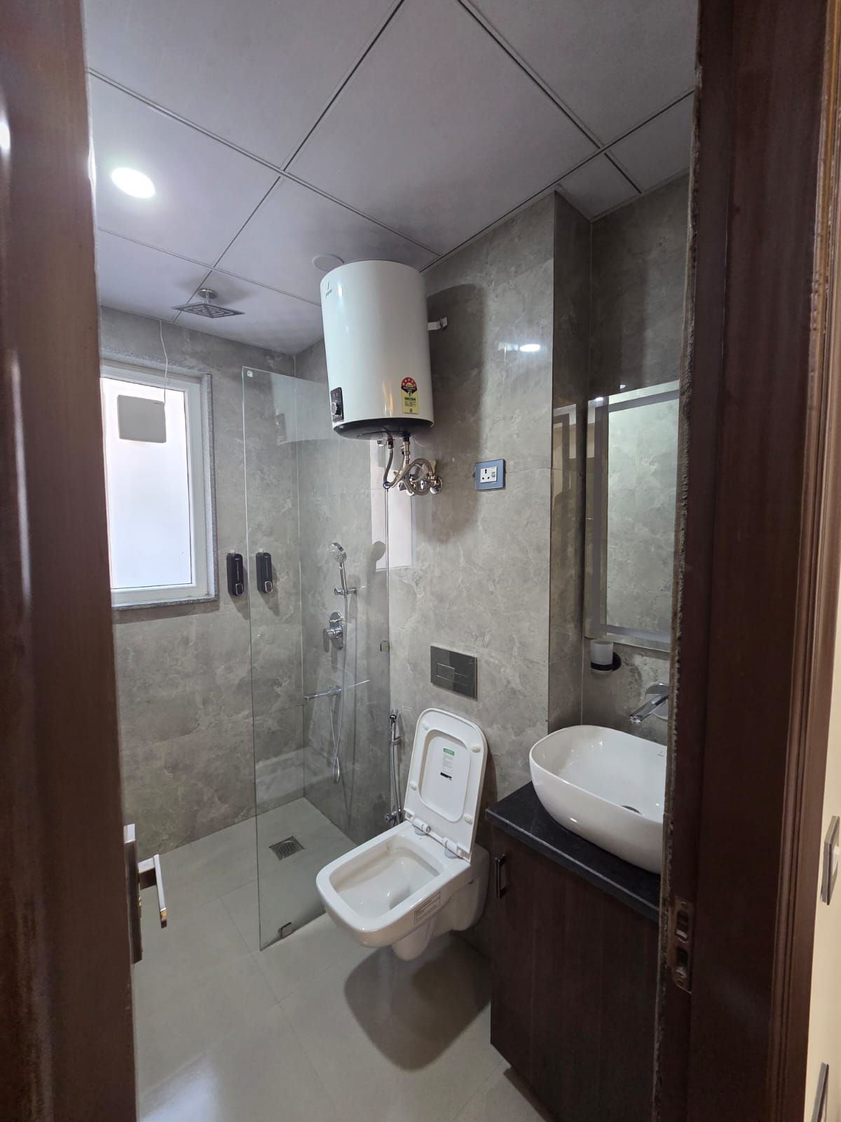 Casa de banho com sanita, lavatório, chuveiro e esquentador.