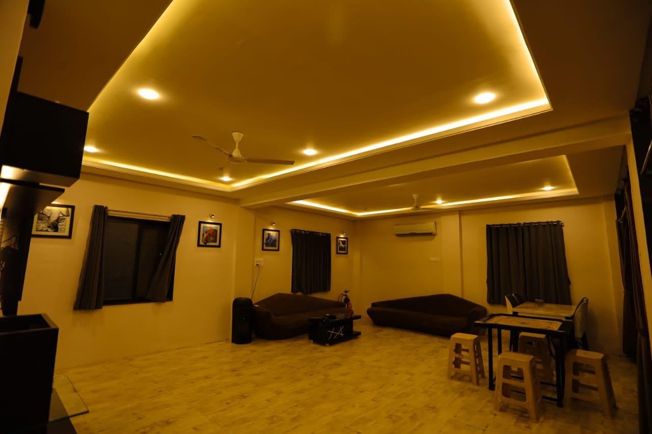 Sala de estar com sofá, mesa de centro, televisão e ventilador de teto.