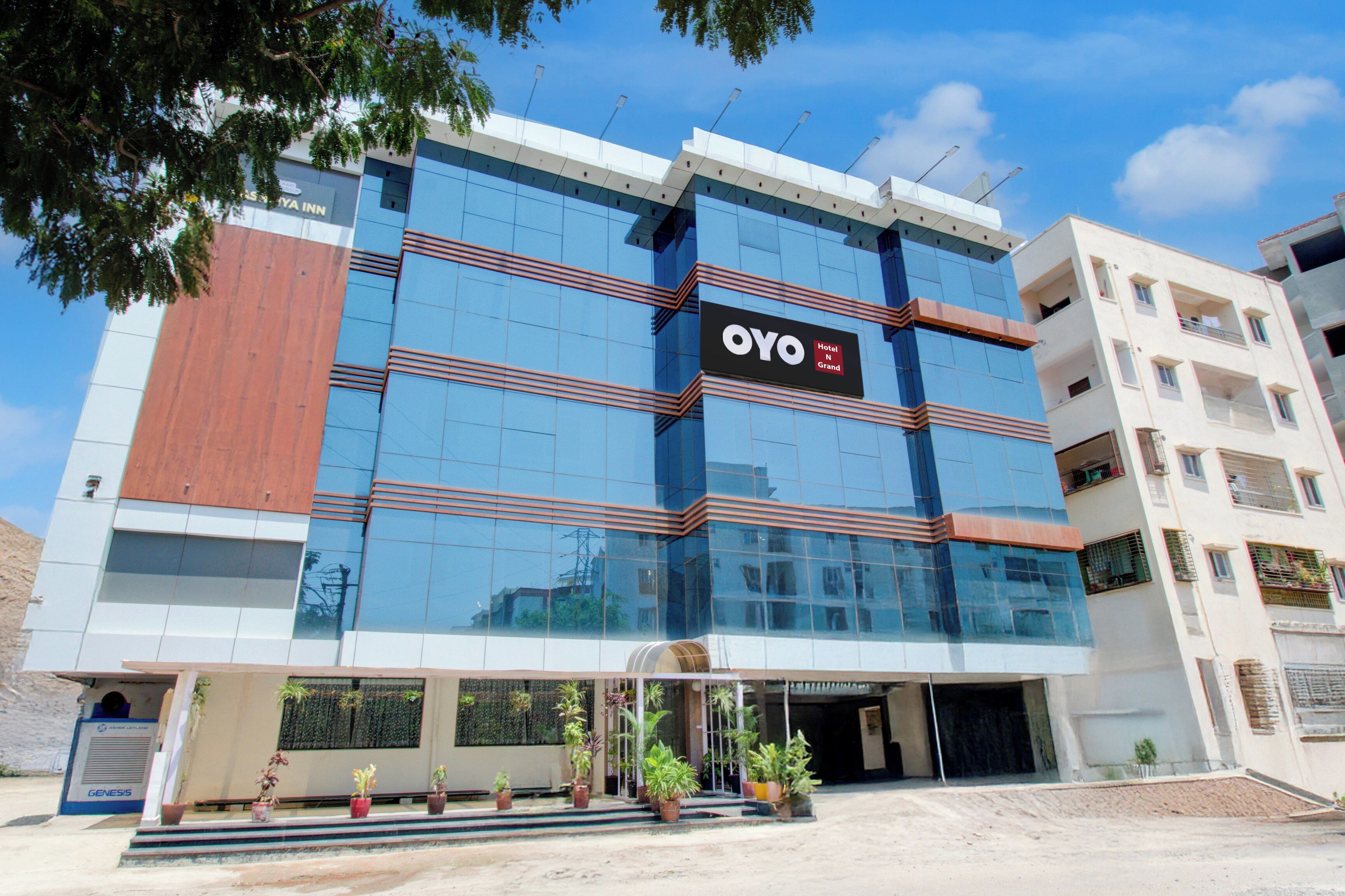 Um edifício de hotel moderno com uma placa de destaque para OYO Hotel Grand.