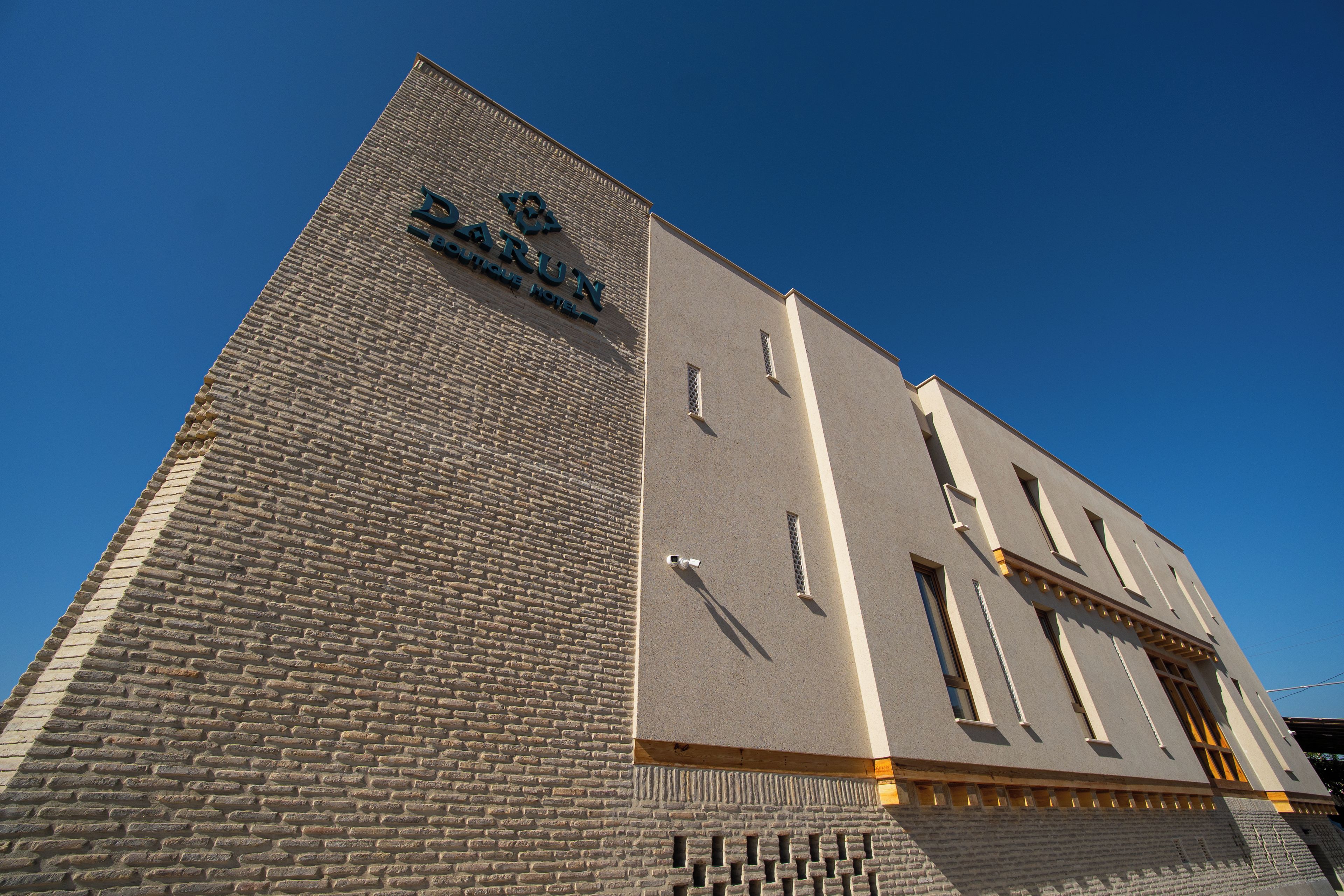 Um edifício com fachada de tijolos e uma placa que diz 'DARUN Boutique Hotel'.