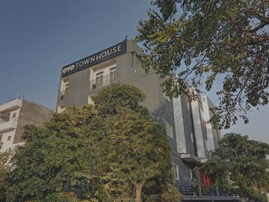Edifício com placa indicando 'YO TOWN HOUSE' e varanda com guarda-corpo.