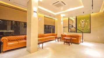 Um interior moderno com um sofá, uma mesinha e um objeto decorativo na parede.