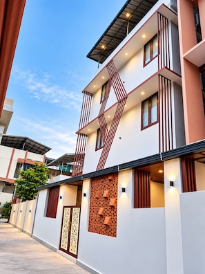 Um edifício moderno de vários andares com telhado plano, janelas amplas e fachada decorativa.