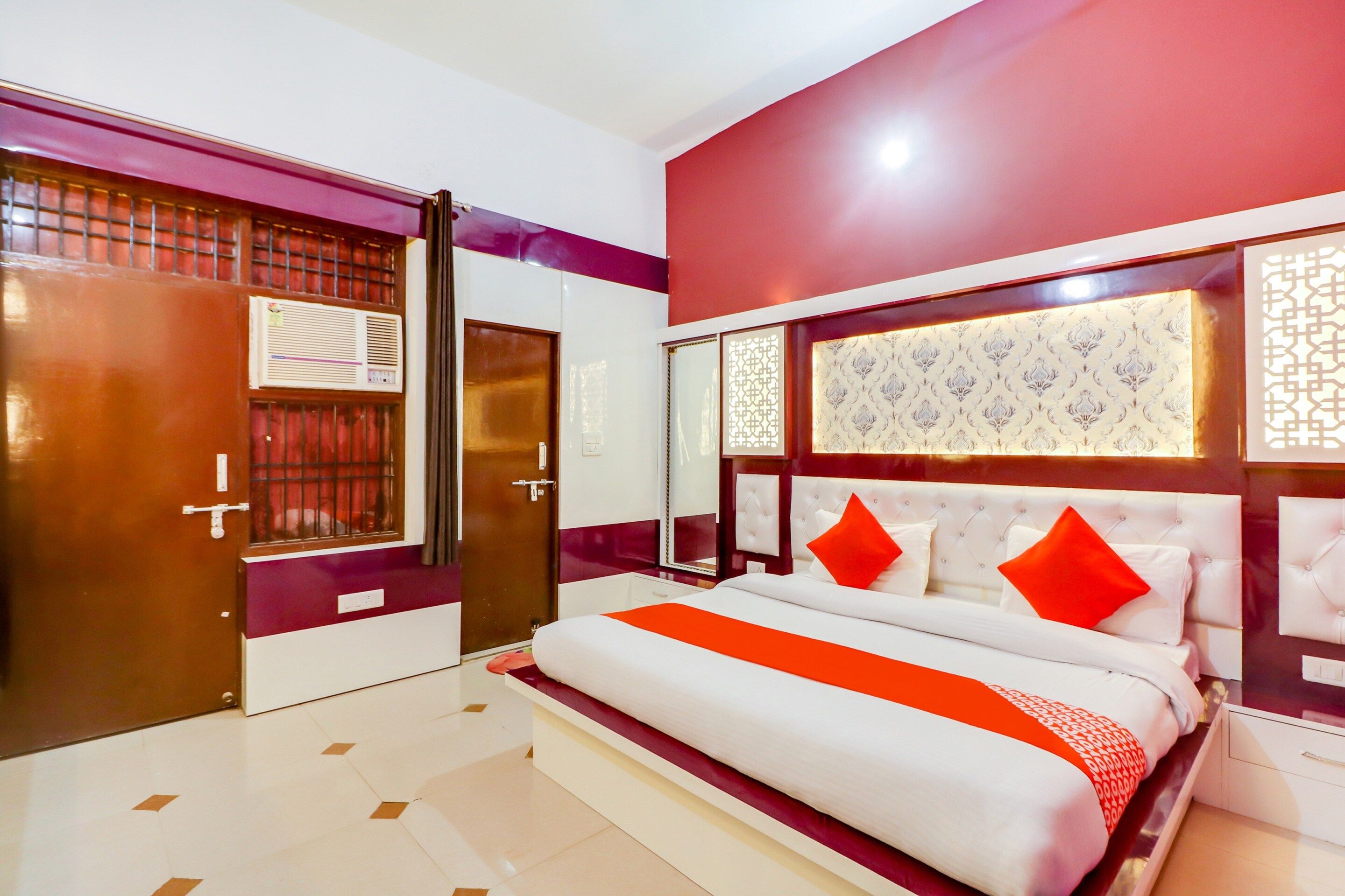 Quarto com cama, guarda-roupa, espelho e janela com grades.