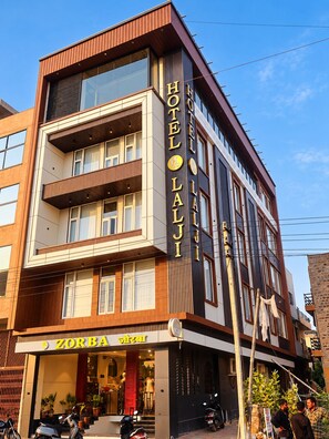 Um hotel de vários andares com uma placa de destaque que diz 'HOTEL ALJUI'.